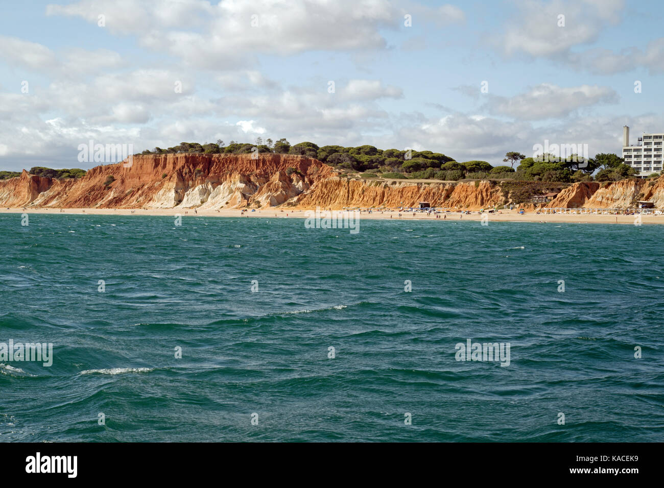 Red cliffs and caves on the Algarve coast, Portugal seen from a boat ...
