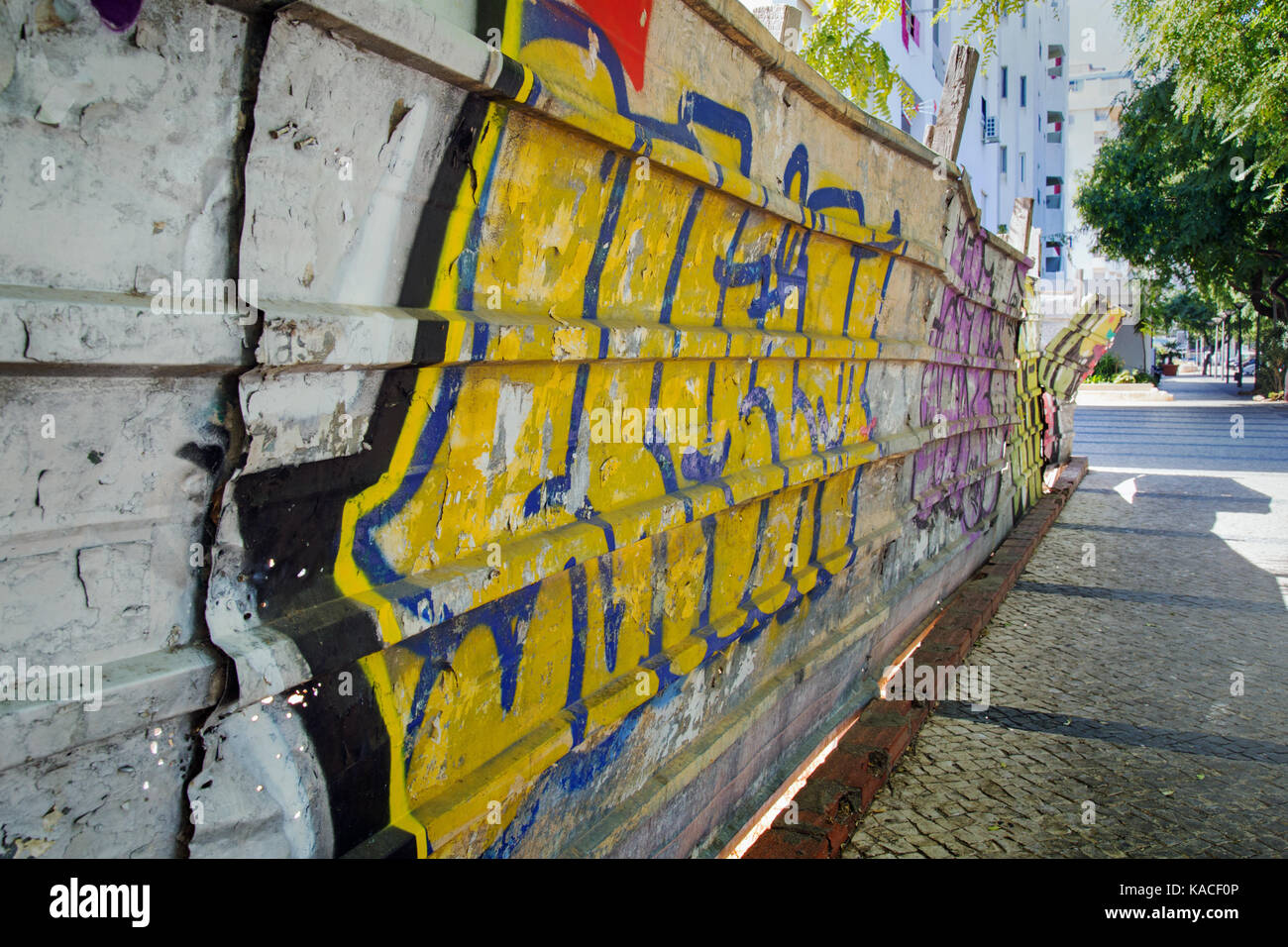 Steel fence with yellow graffiti shot along the fence Stock Photo - Alamy
