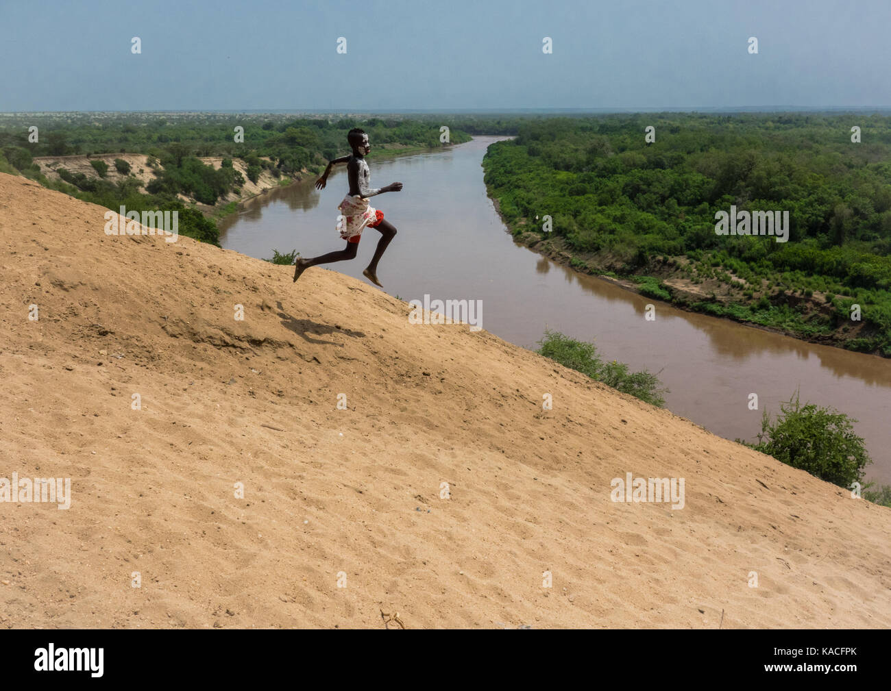 Karo tribe boy jumping in front of Omo river, Omo valley, Korcho ...