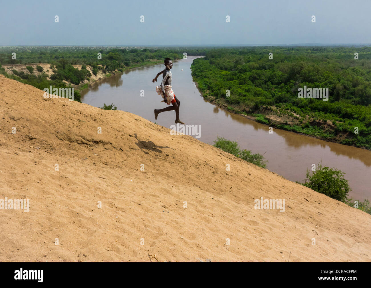 Karo tribe boy jumping in front of Omo river, Omo valley, Korcho ...