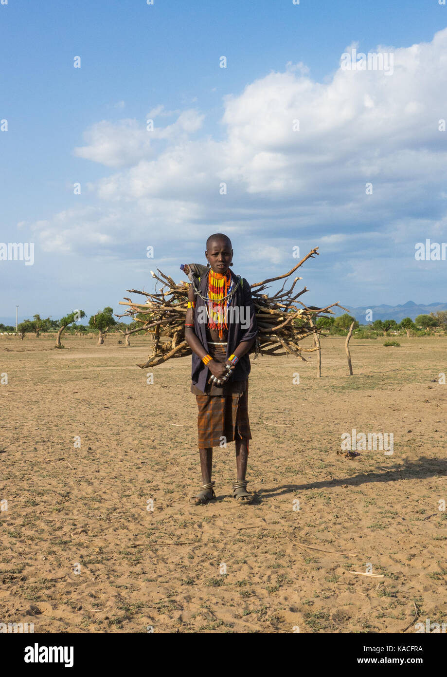 Erbore tribe kid carrying wood in Murale village, Omo valley, Ethiopia ...