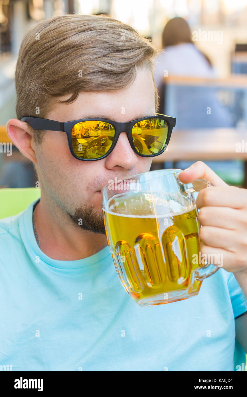 Man drinking beer. Handsome young hipster man drinking beer while ...