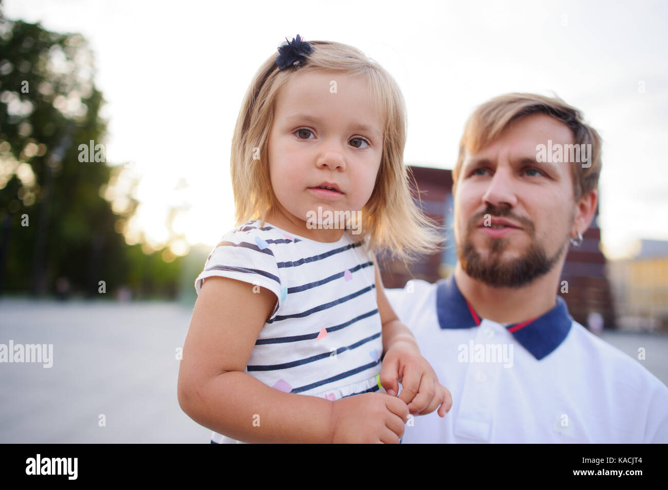 Young father holds the little daughter on hands. Man gently presses to ...