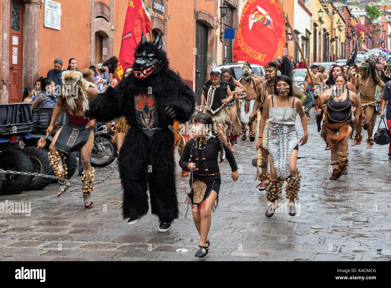 A costumed wolf dances in a procession through the historic city during ...