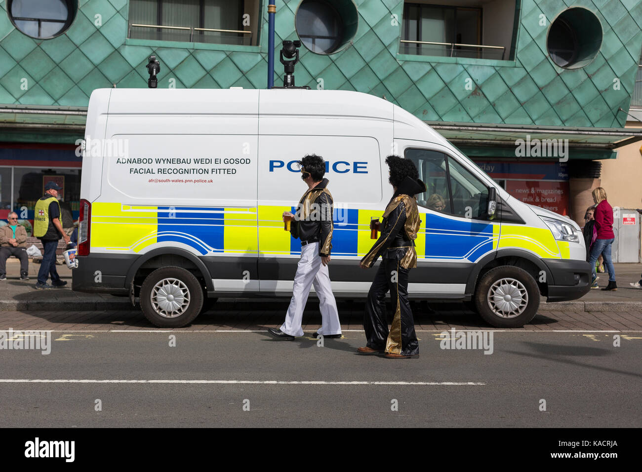 Two elvis fans walk in front of police face recognition van Stock Photo ...