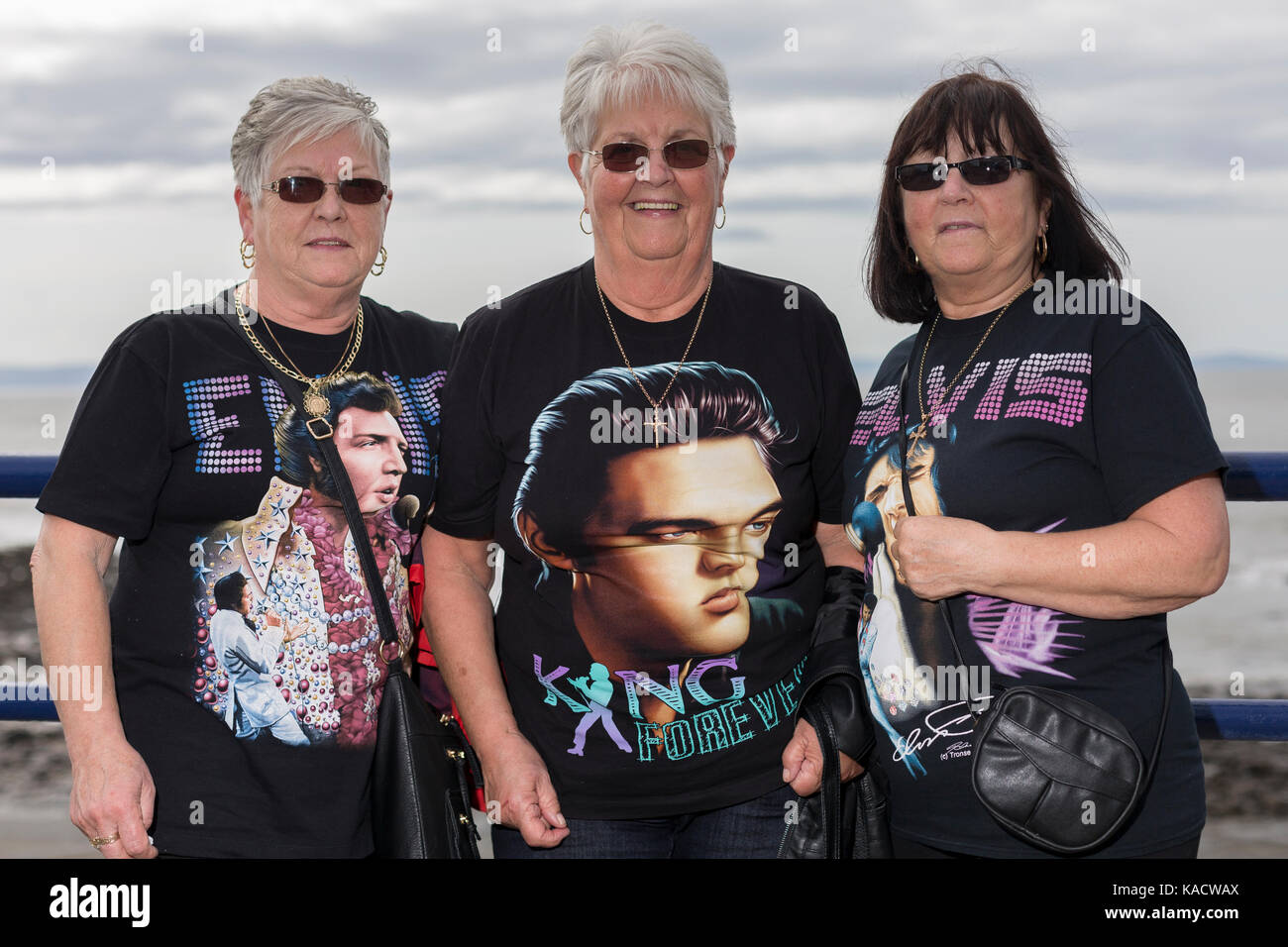 Three Elvis women fans wearing black elvis T shirts and sunglasses ...
