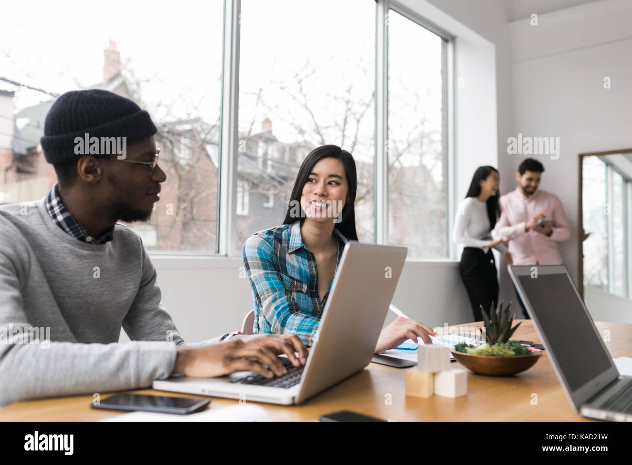 Young business people collaborating Stock Photo - Alamy