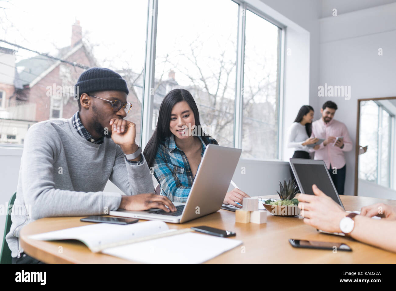 Young business people collaborating Stock Photo - Alamy