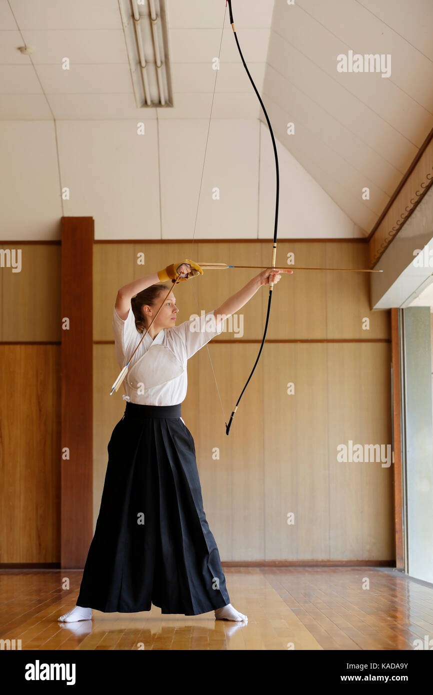 Caucasian woman practicing traditional Kyudo Japanese archery Stock ...