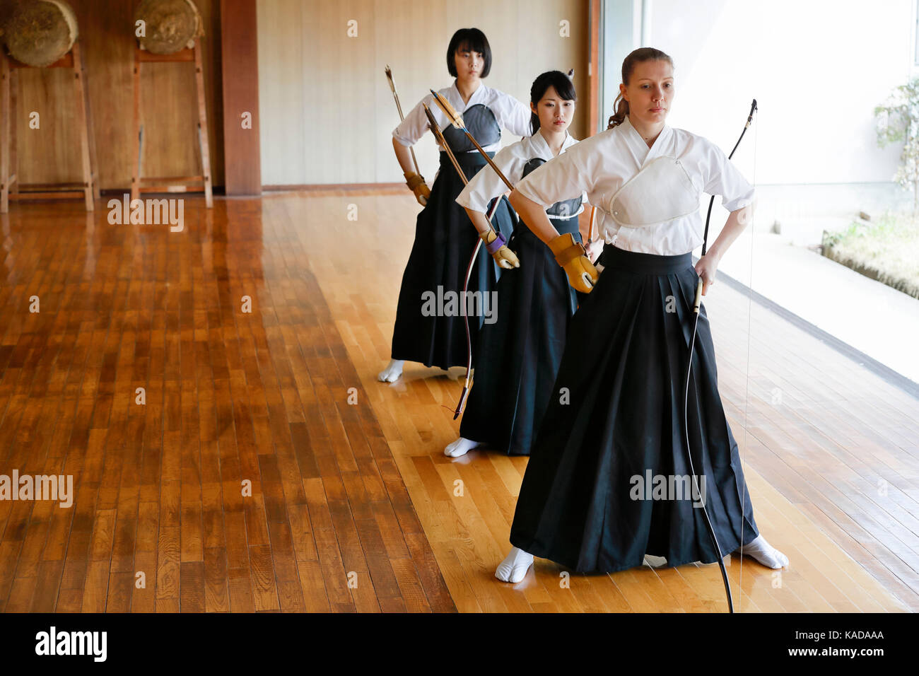 Multi-ethnic traditional Kyudo Japanese archery athletes practicing ...