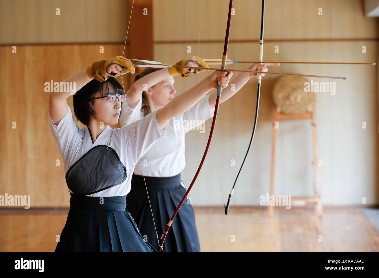 Multi-ethnic traditional Kyudo Japanese archery athletes practicing ...