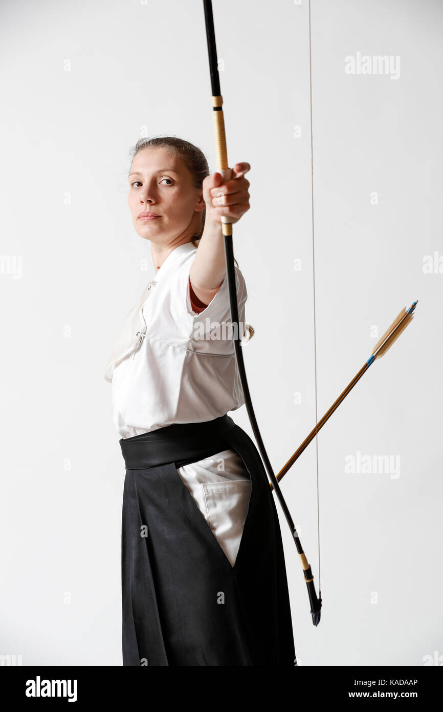Caucasian woman practicing traditional Kyudo Japanese archery on white background Stock Photo ...