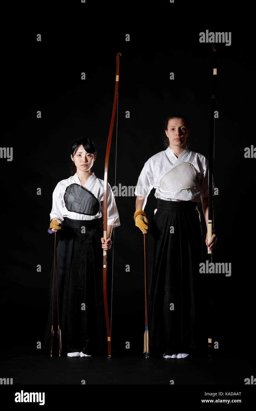 Multi-ethnic traditional Kyudo Japanese archery athletes on black ...