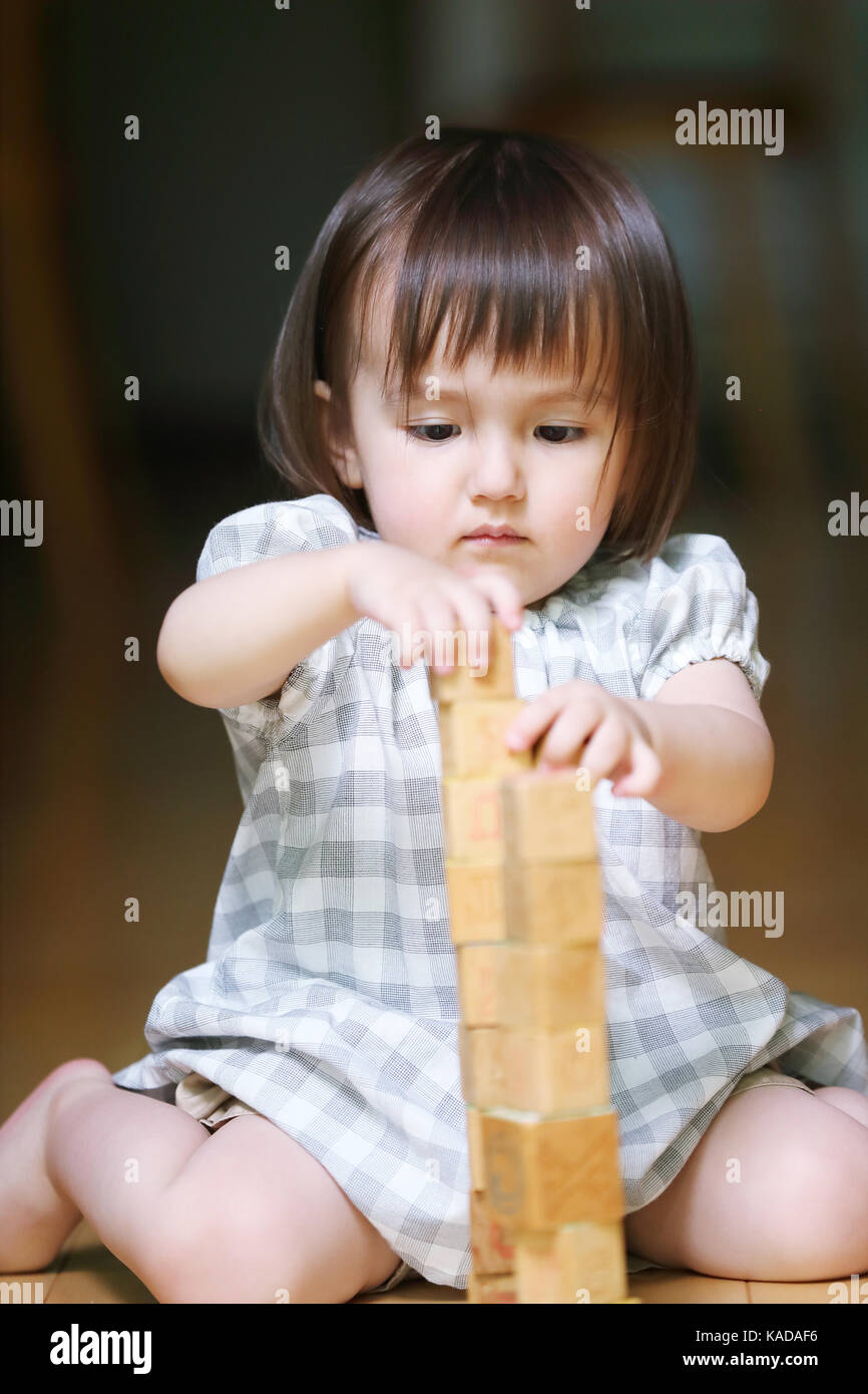 Mixed-race young girl with wooden blocks Stock Photo - Alamy