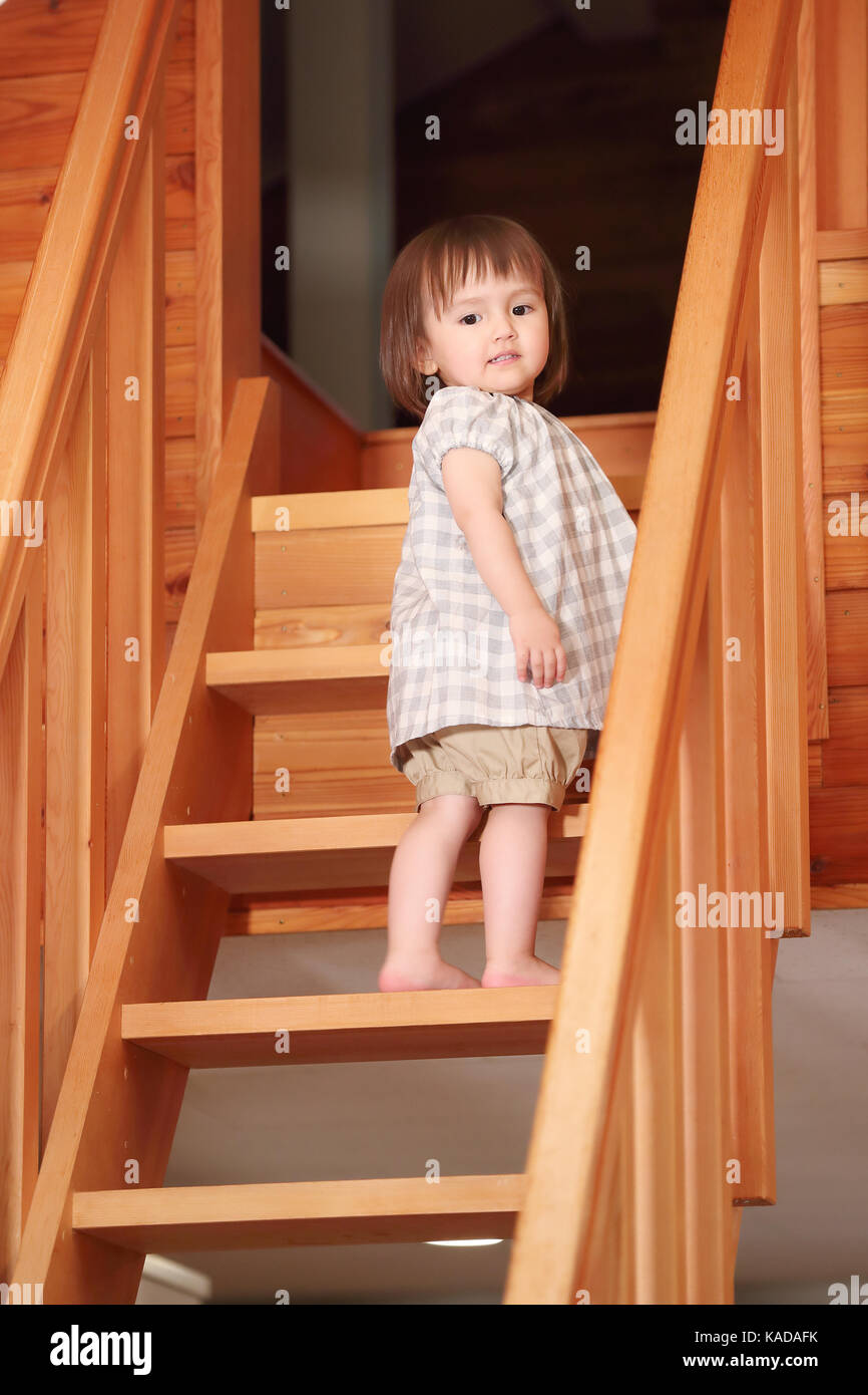 Mixed-race young girl on wooden stairs Stock Photo - Alamy