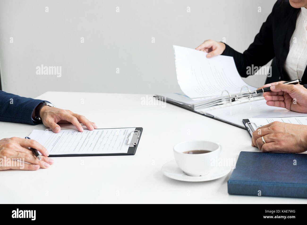 Businessman conducting an interview with businessman in an office Stock ...