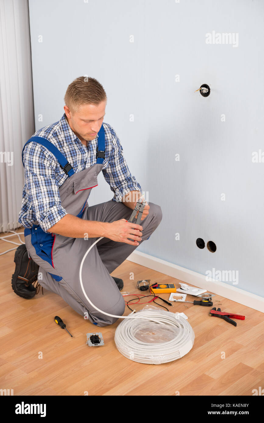 Young Electrician Working With Wire With Plier In House Stock Photo - Alamy