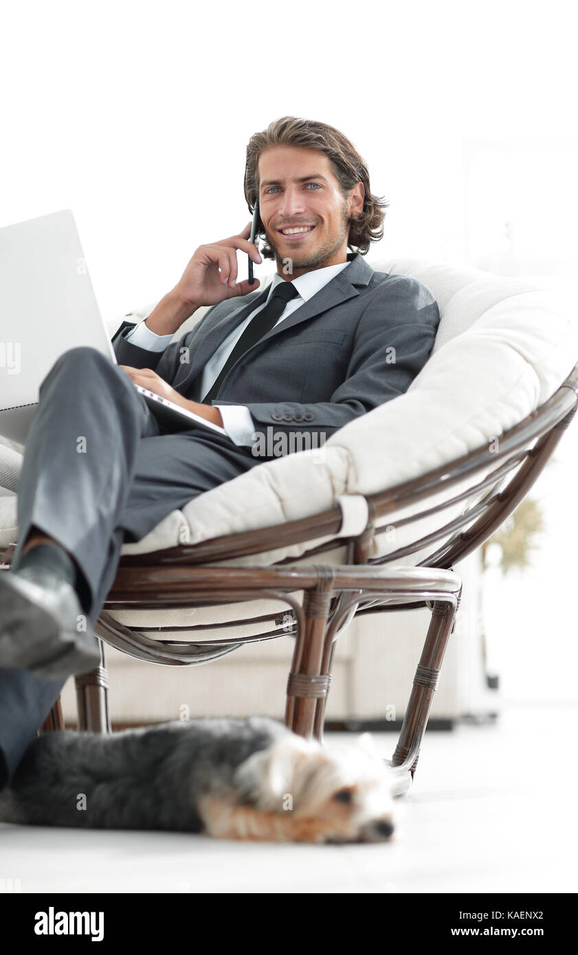 businessman talking on smartphone sitting in chair in his house Stock ...