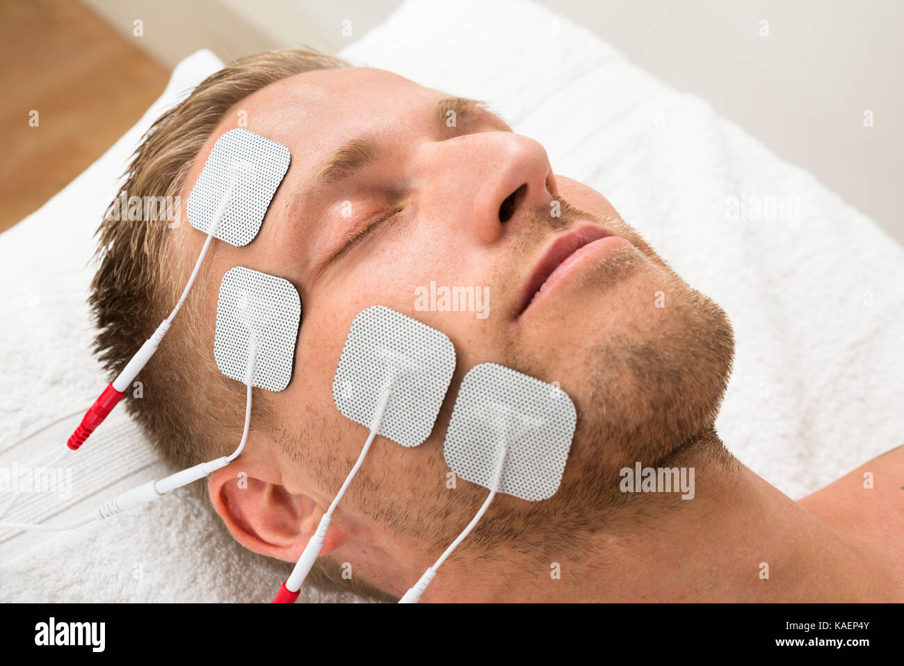 Close-up Of Young Man Closing Eyes With Electrodes On Face Stock Photo ...