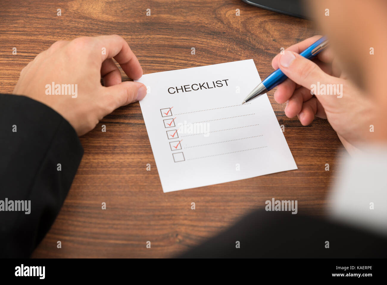 Close-up Of A Person's Hand Marking On Checklist With Pen Stock Photo ...