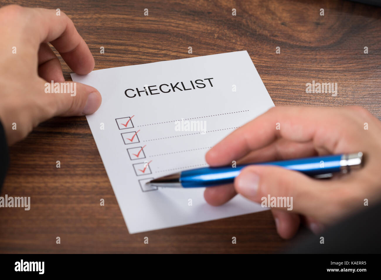 Close-up Of A Person's Hand Marking On Checklist With Pen Stock Photo ...
