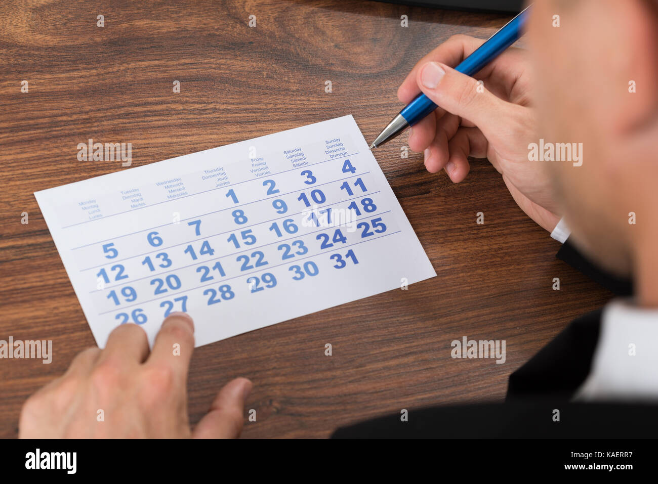 Close-up Of Man Marking With Pen And Looking At Date On Calendar Stock ...