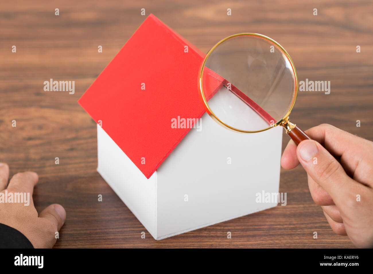 Close-up Of Person Hands With Magnifying Glass Inspecting A Model House ...