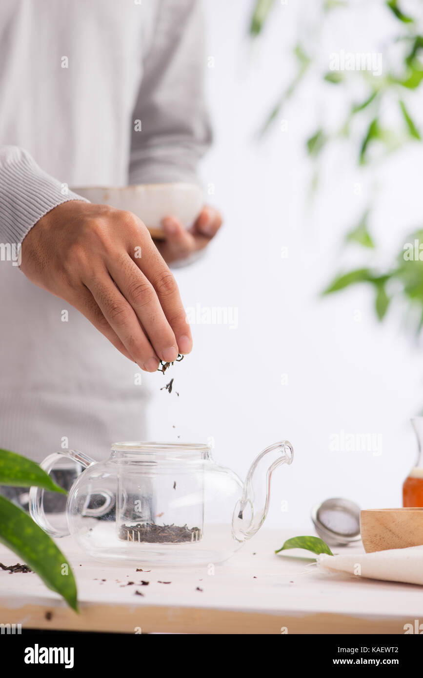 Male hands with dry black tea falling Stock Photo - Alamy