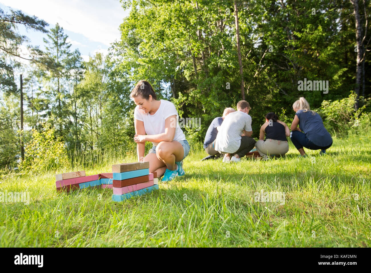 Female Crouching By Building Blocks While Friends Planning On Fi Stock ...