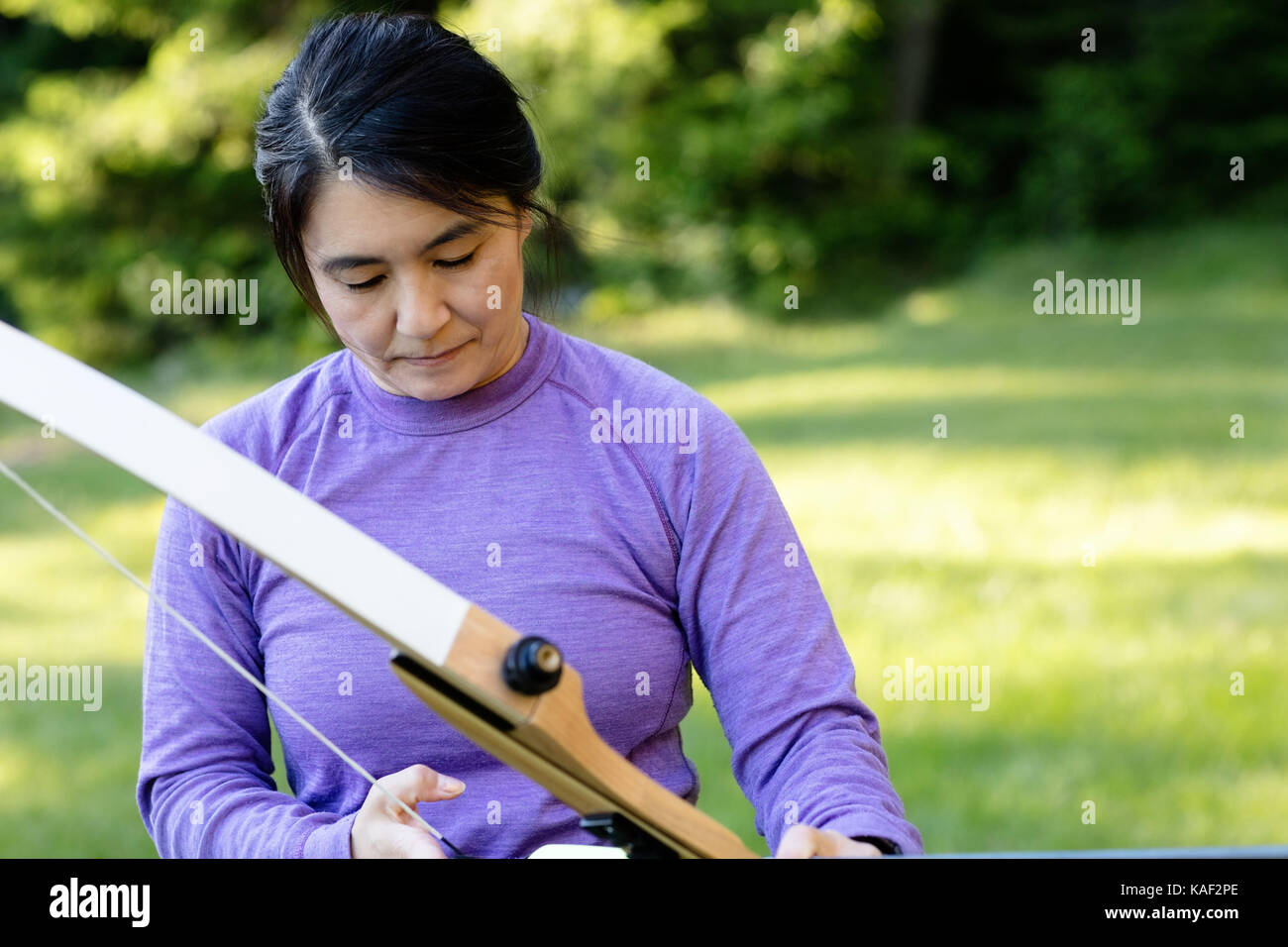 Mature Female Archer Holding Bow In Forest Stock Photo - Alamy