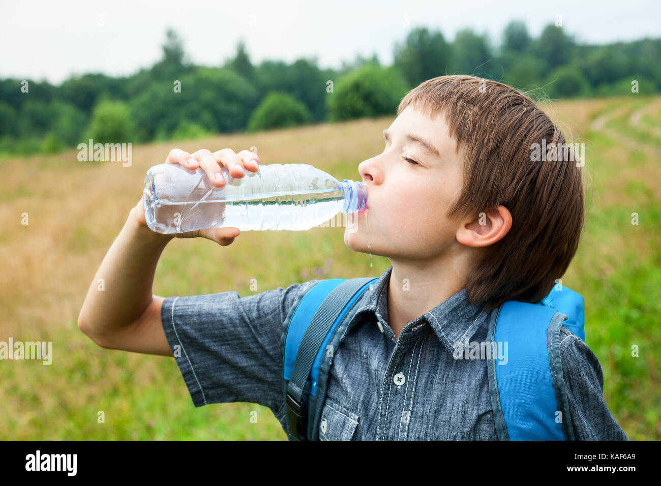 Boy drinking water from pet bottle outdoors Stock Photo - Alamy