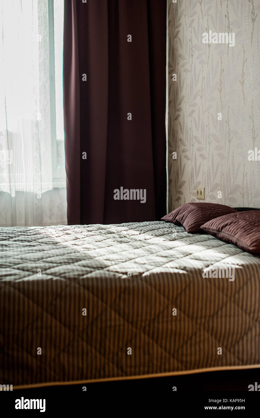 tucked bed in a room with sunlight Stock Photo - Alamy