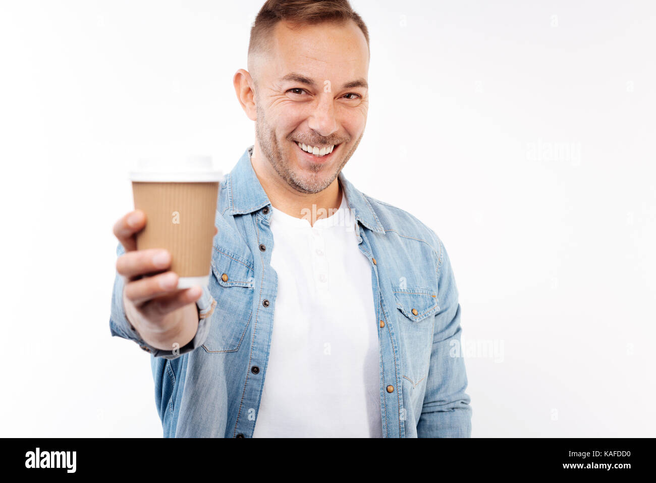 Pleasant smiling man handing a cup of coffee Stock Photo - Alamy