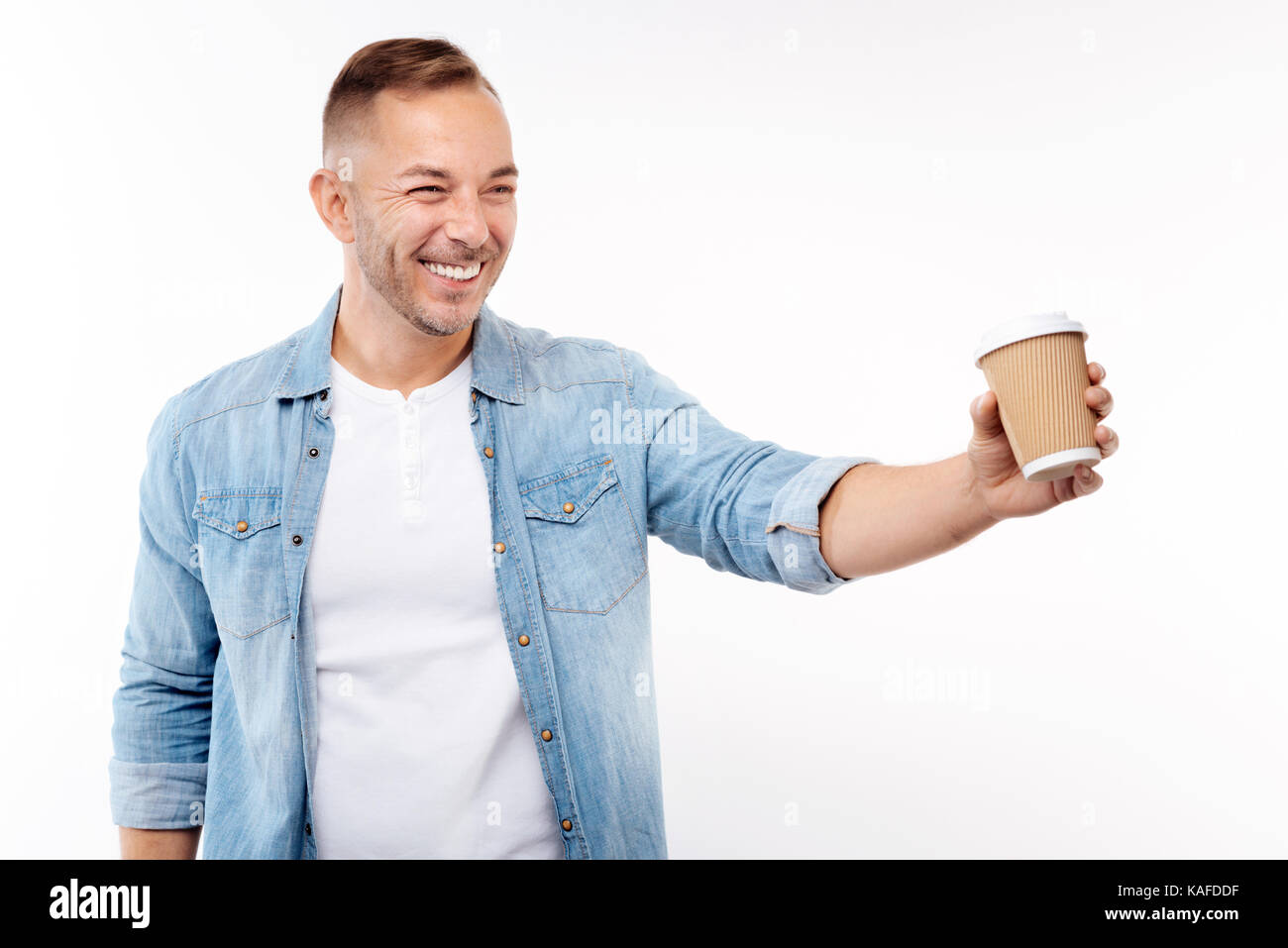 Cheerful young man giving a paper cup of coffee Stock Photo - Alamy