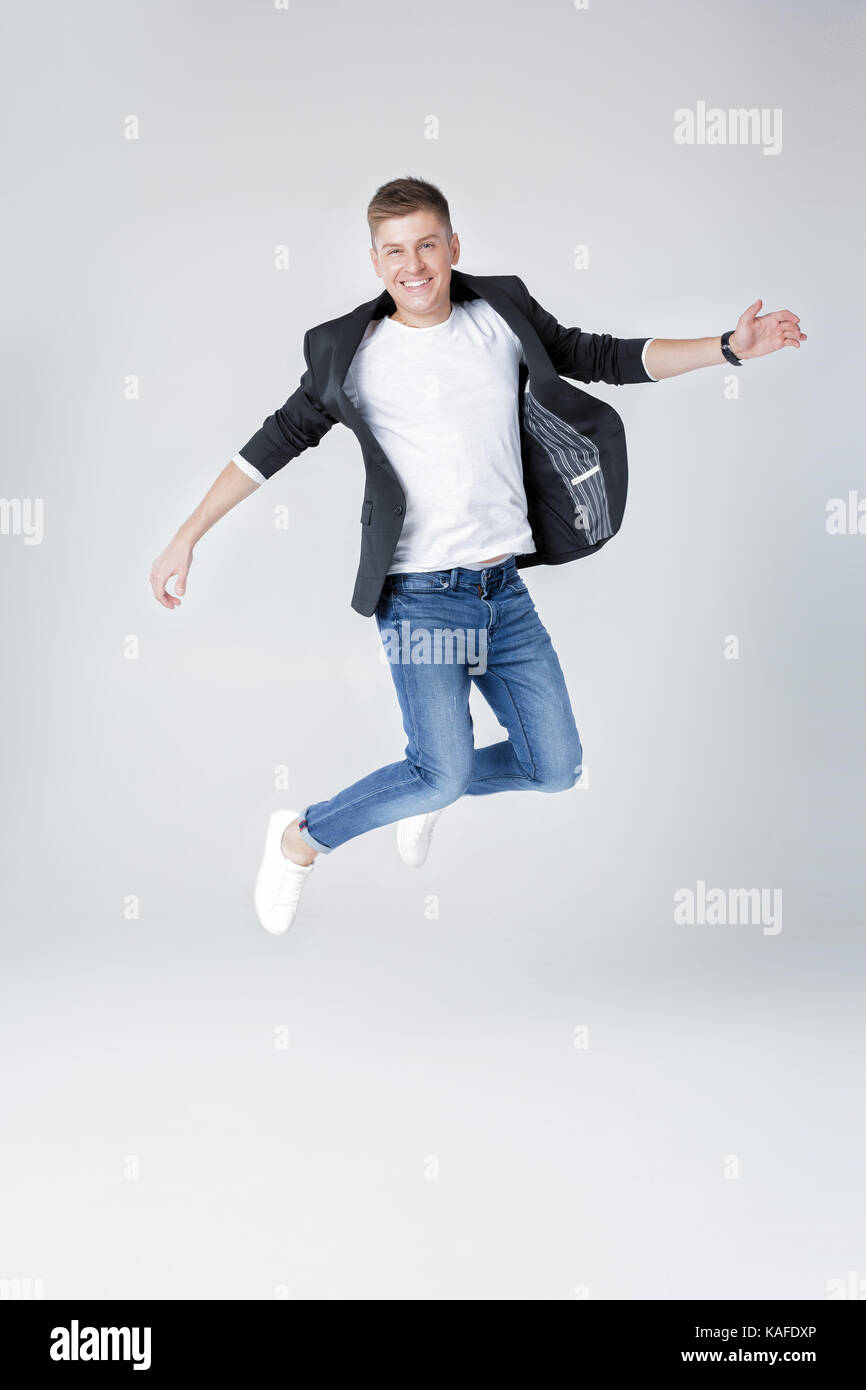 handsome man in jeans and jacket jumping Stock Photo - Alamy