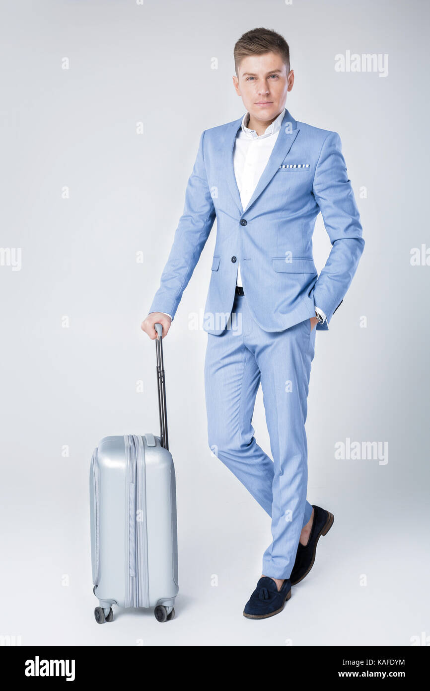 young man in blue suit with suitcase Stock Photo - Alamy