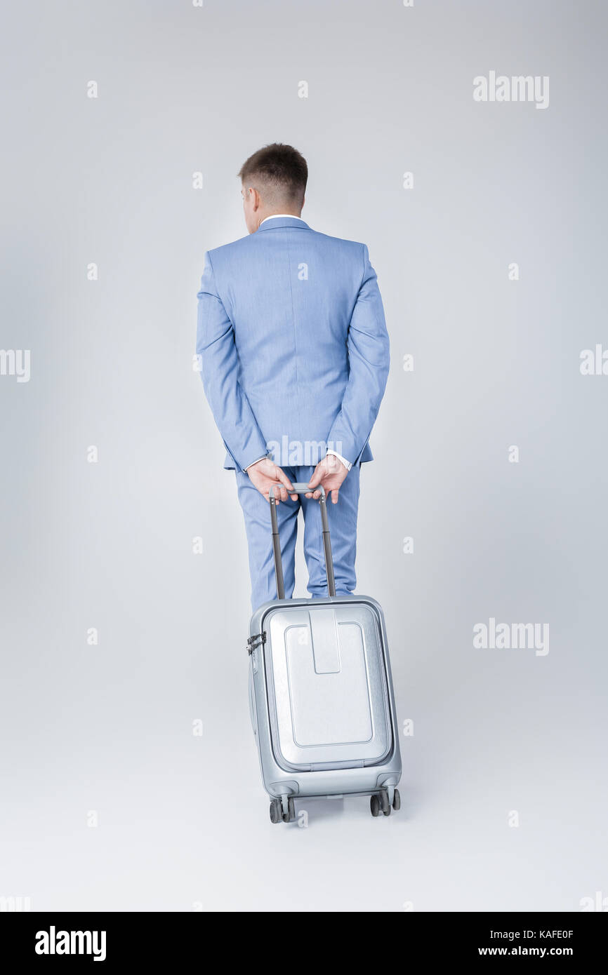 young man in blue suit with suitcase Stock Photo - Alamy
