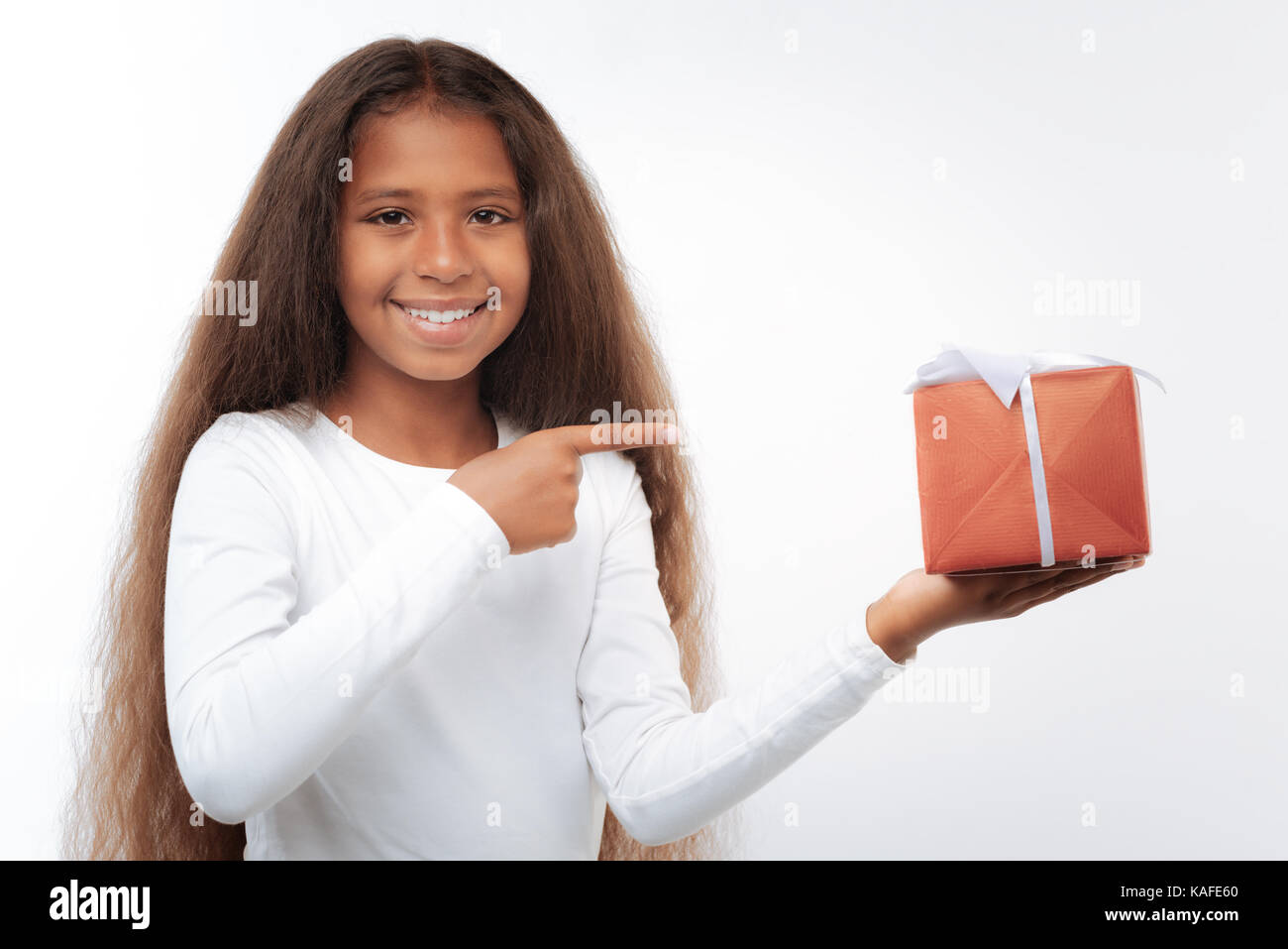 Charming girl pointing at gift box with finger Stock Photo - Alamy