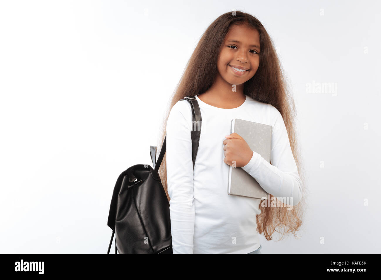 Pretty girl with backpack pressing notebook to her chest Stock Photo ...