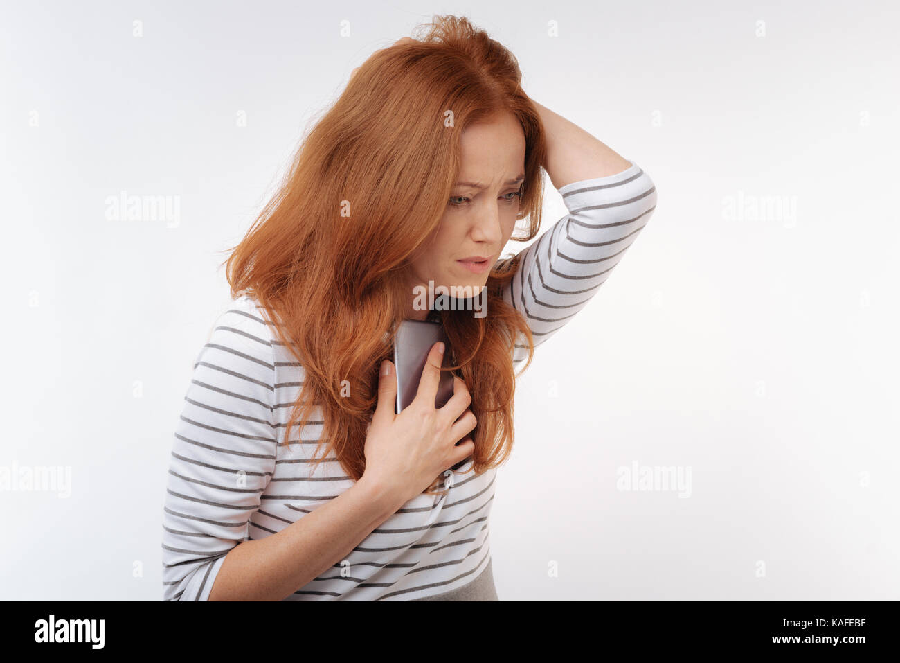 Ginger-haired woman being upset after reading message Stock Photo - Alamy