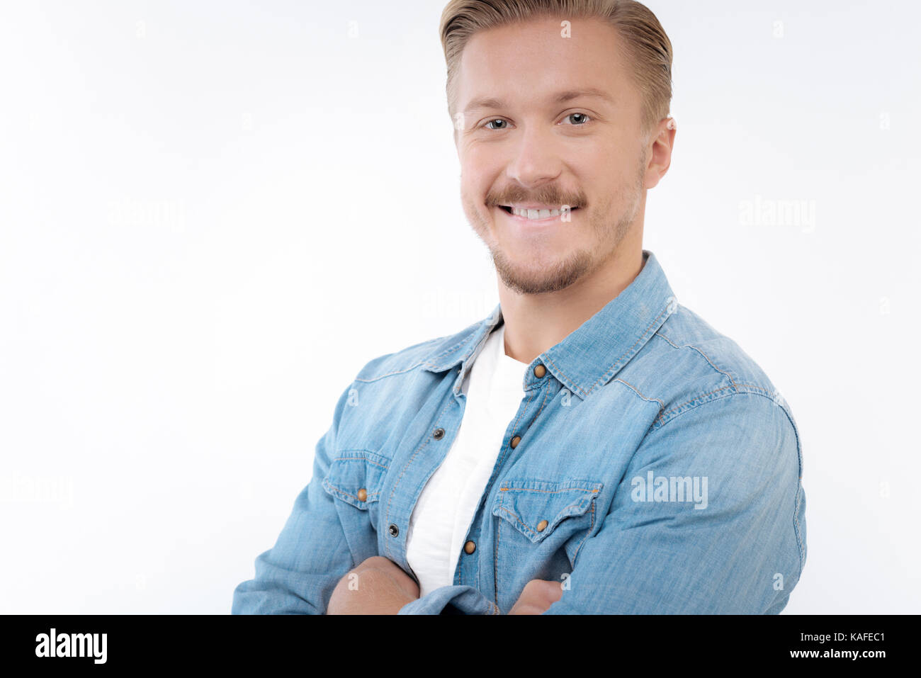 Cheerful fair-haired man posing with his arms folded Stock Photo - Alamy