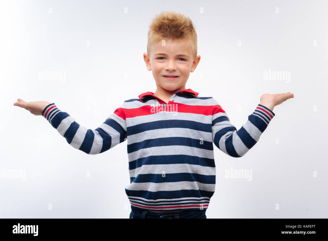 Smiling fair-haired boy spreading hands Stock Photo - Alamy