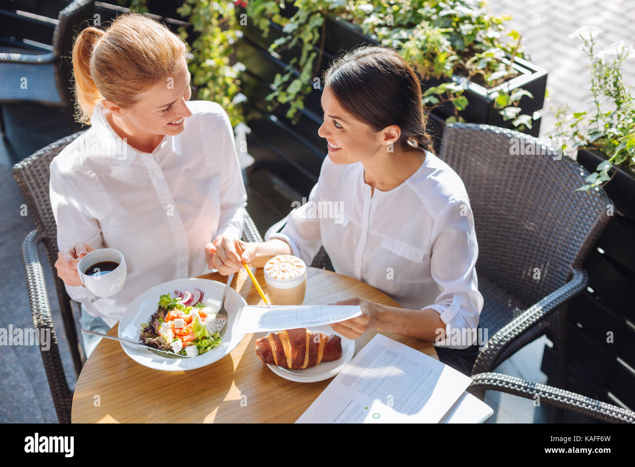 Beautiful colleagues talking about work at lunch Stock Photo - Alamy