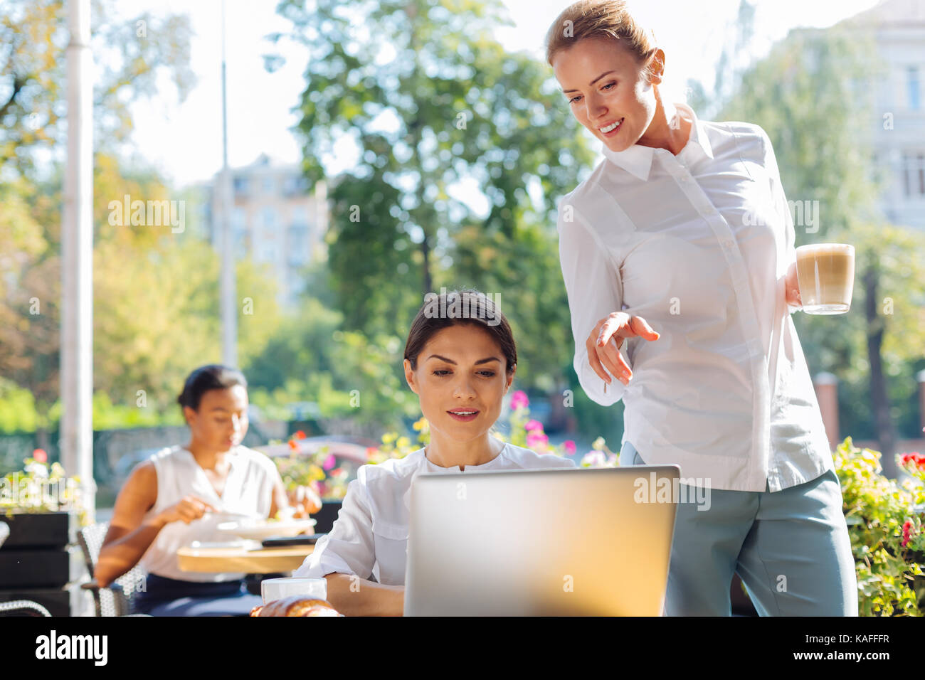 Pleasant woman making a comment about colleagues project Stock Photo ...