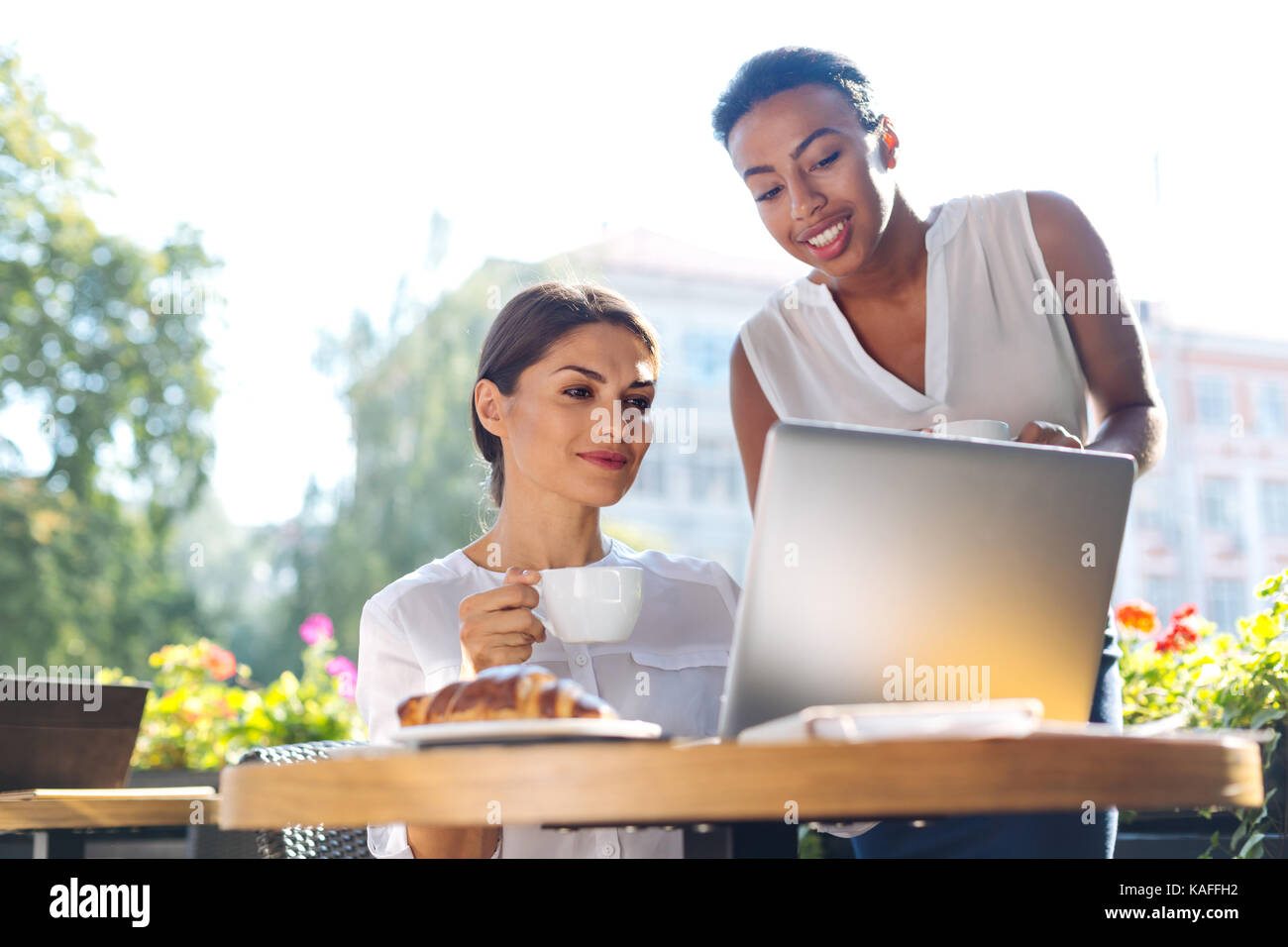 Two beautiful women watching presentation on laptop Stock Photo - Alamy