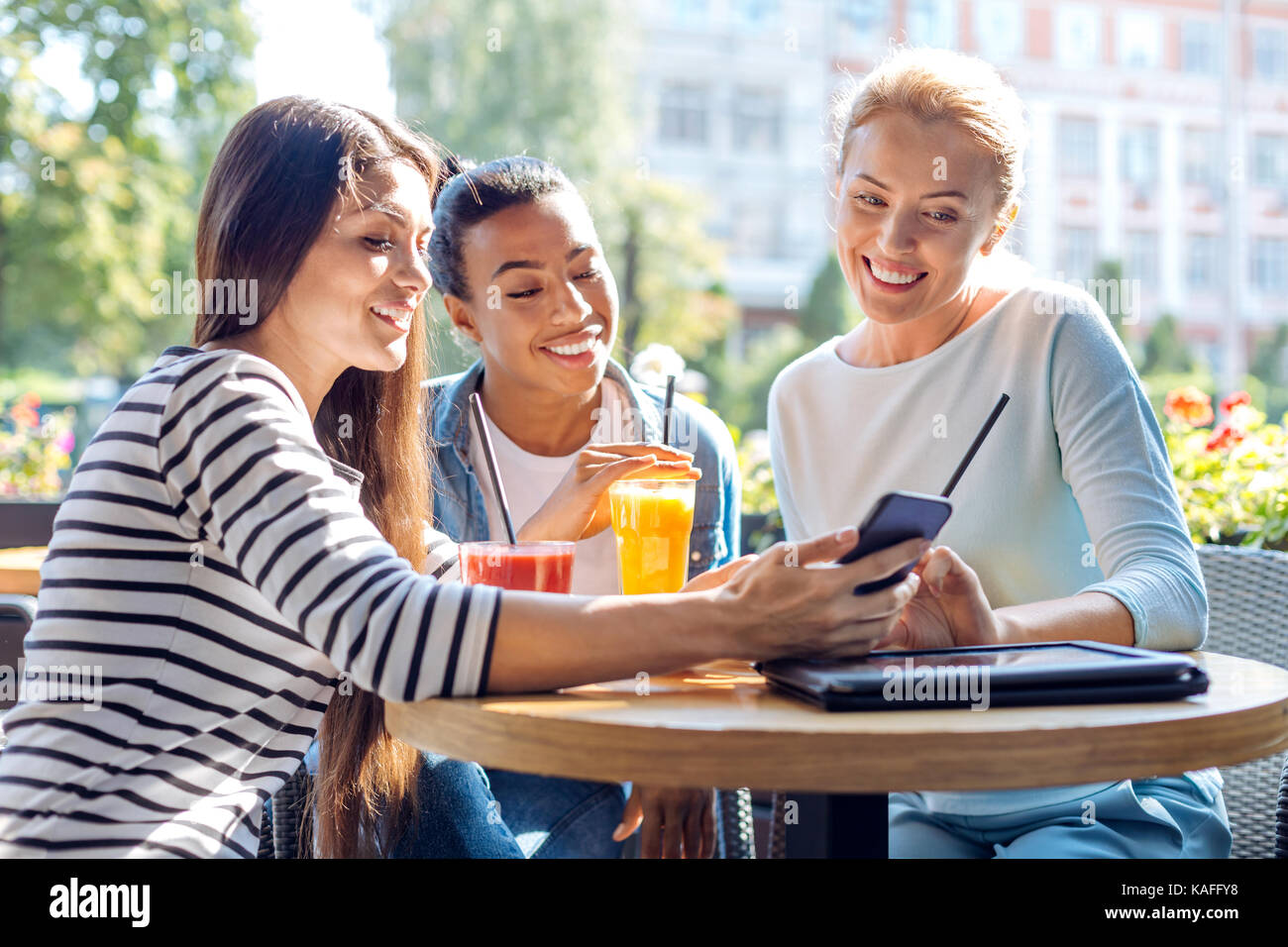 Charming friends taking a selfie together in cafe Stock Photo - Alamy
