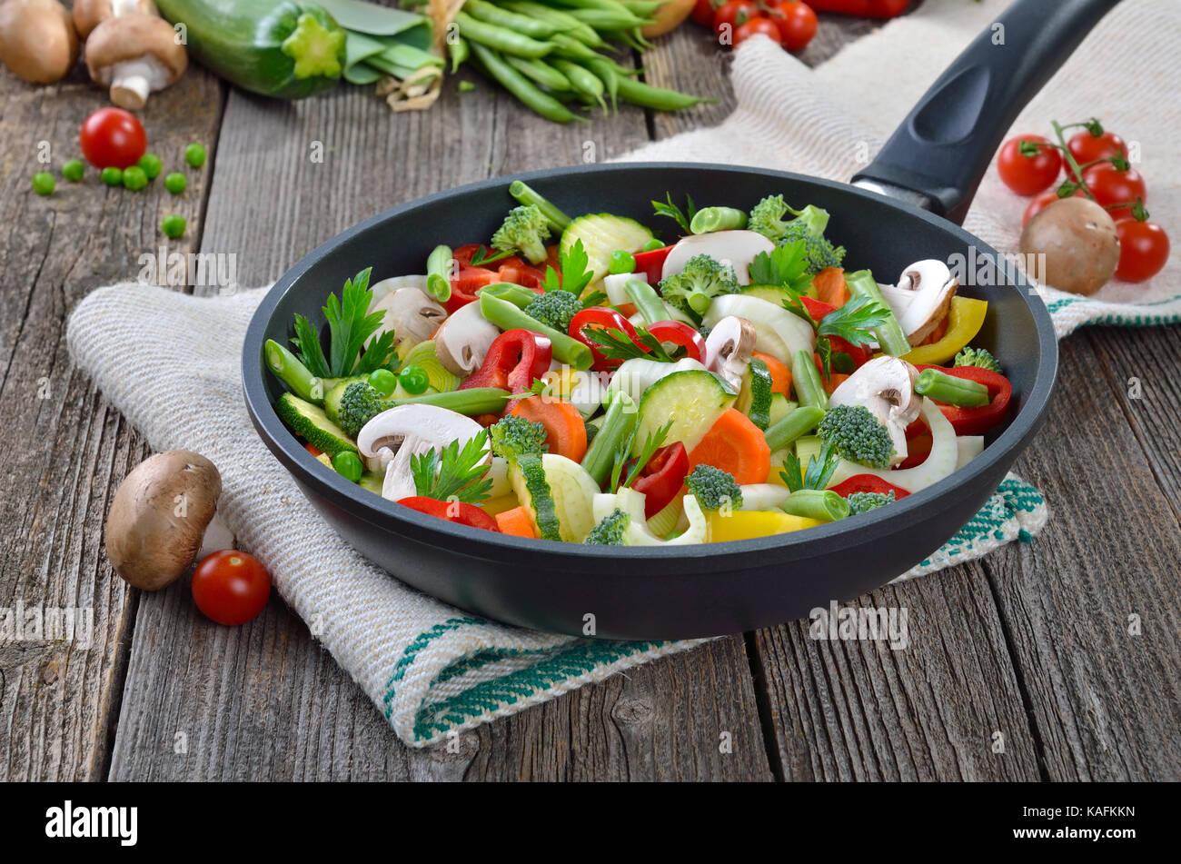 Chopped colorful vegetables in a frying pan, placed o an old linen ...