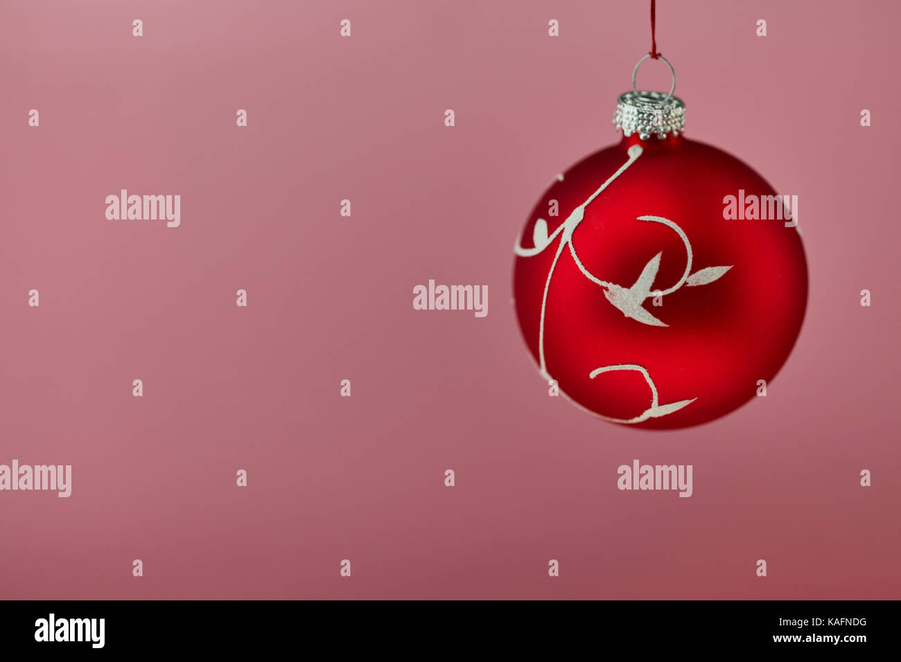 Big red christmas bauble on pink background for card Stock Photo - Alamy