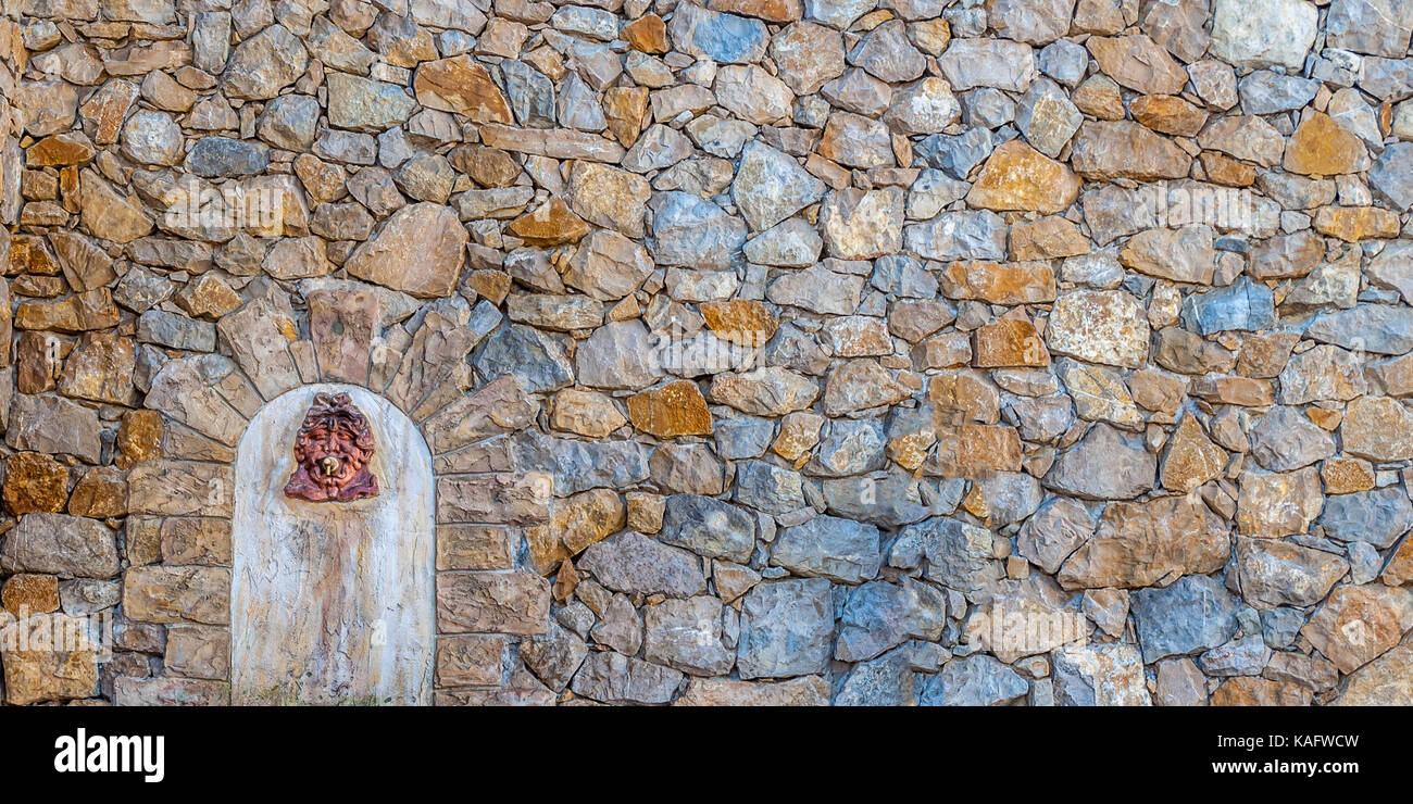 Little fountain on a stone wall with copy space Stock Photo - Alamy