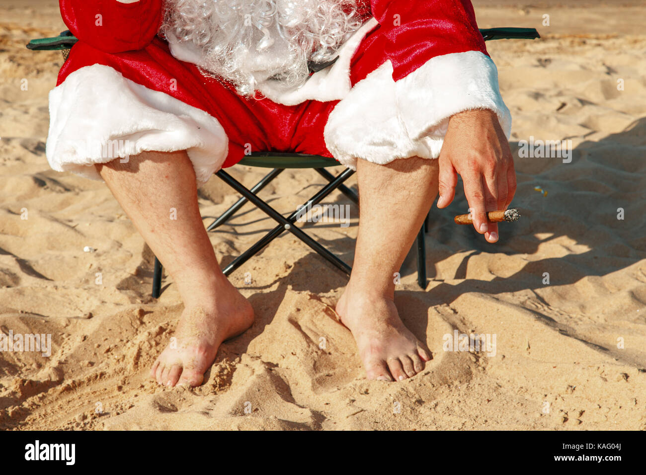 Santa Claus on the beach sits in a chair and smokes a cigar. Vintage ...